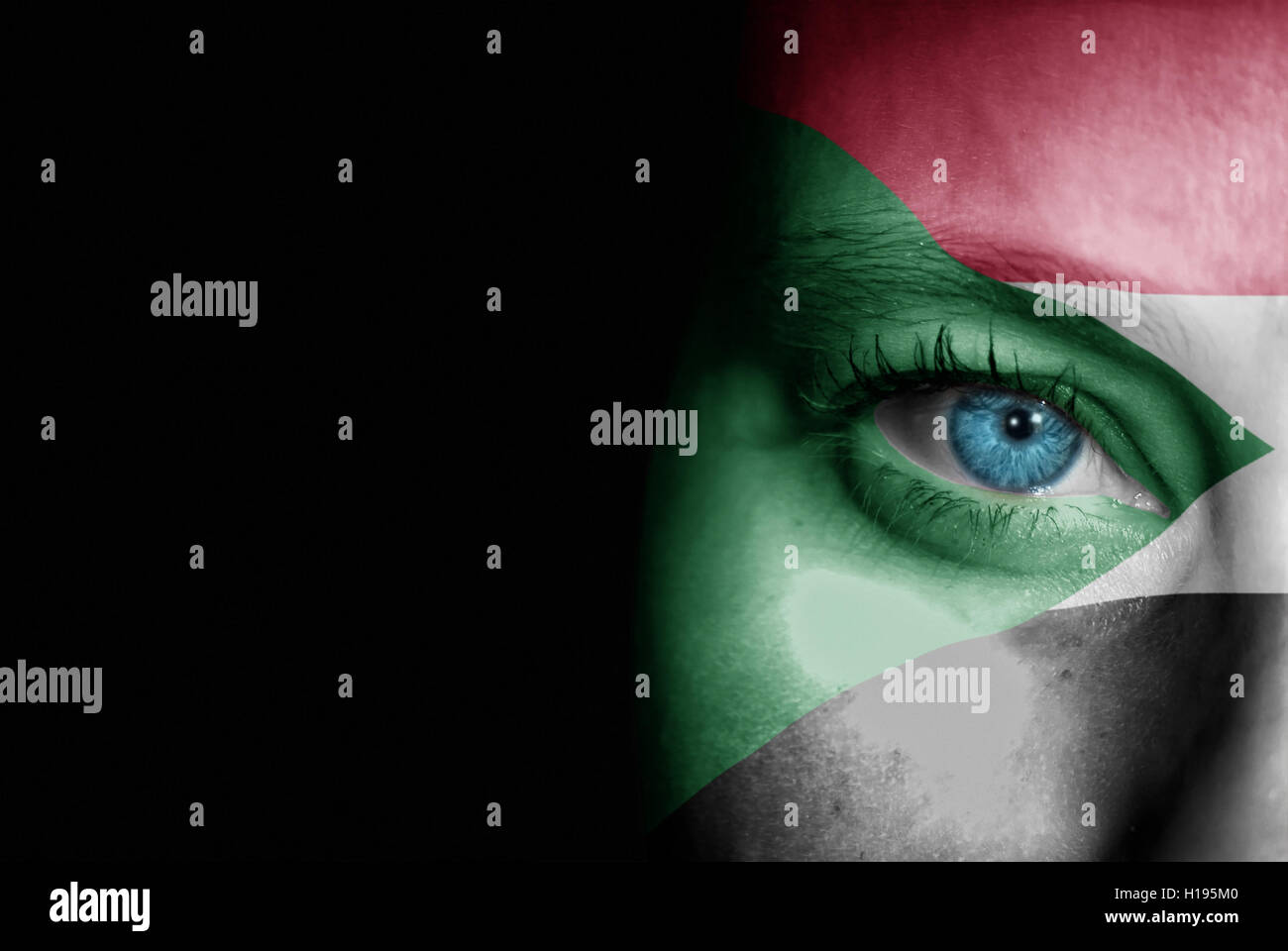 A young female with the flag of Sudan painted on her face on her way to ...
