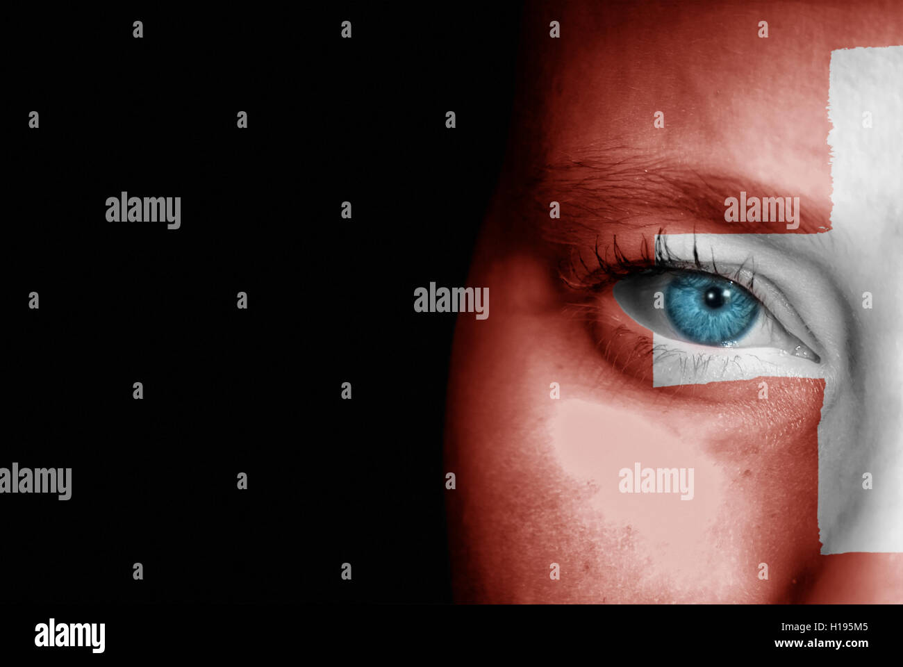 A young female with the flag of Switzerland painted on her face on her ...