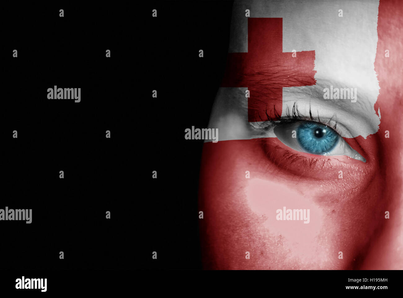 A young female with the flag of Tonga painted on her face on her way to ...