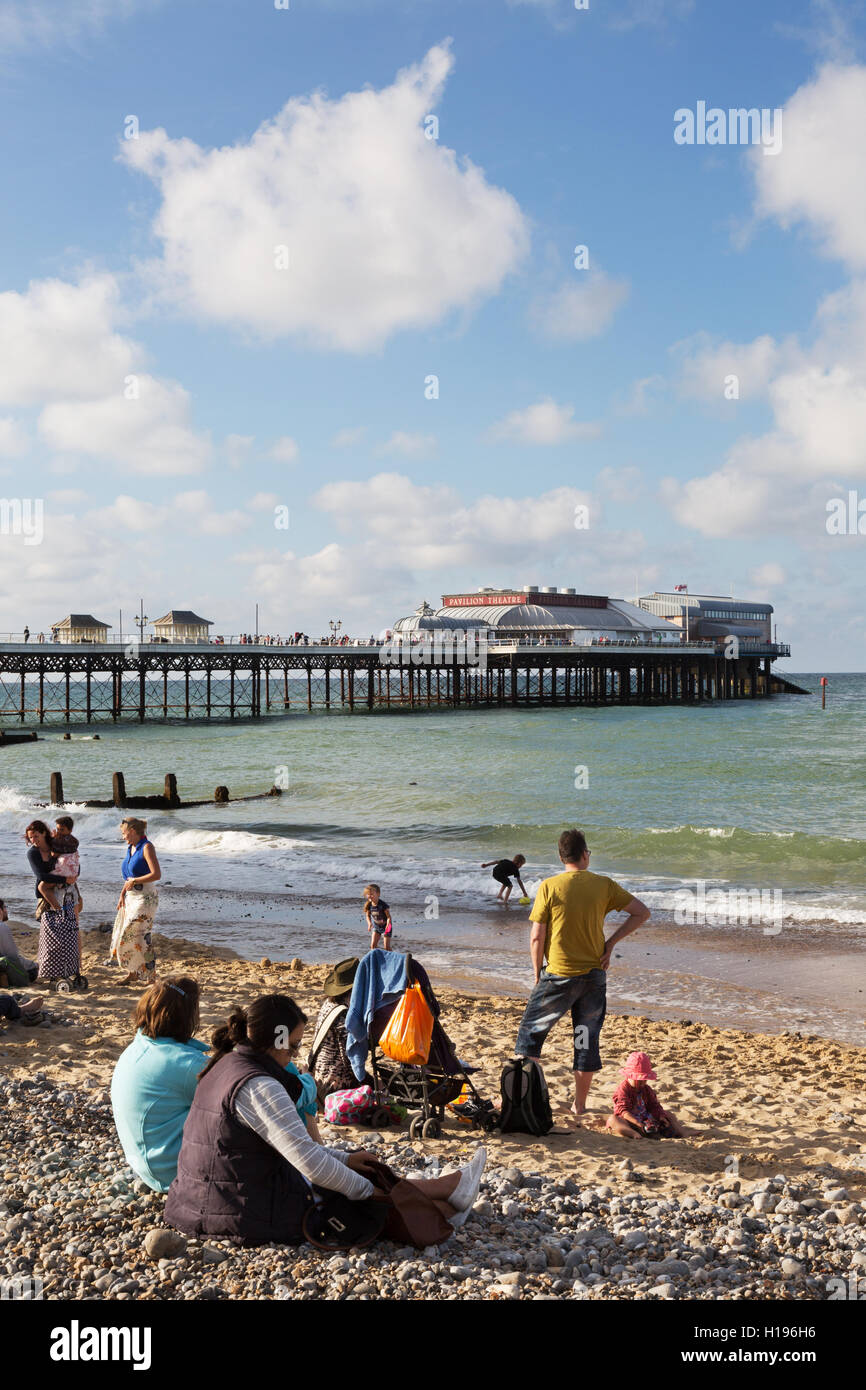 People sitting on Cromer beach, with Cromer pier, Cromer, north Norfolk ...