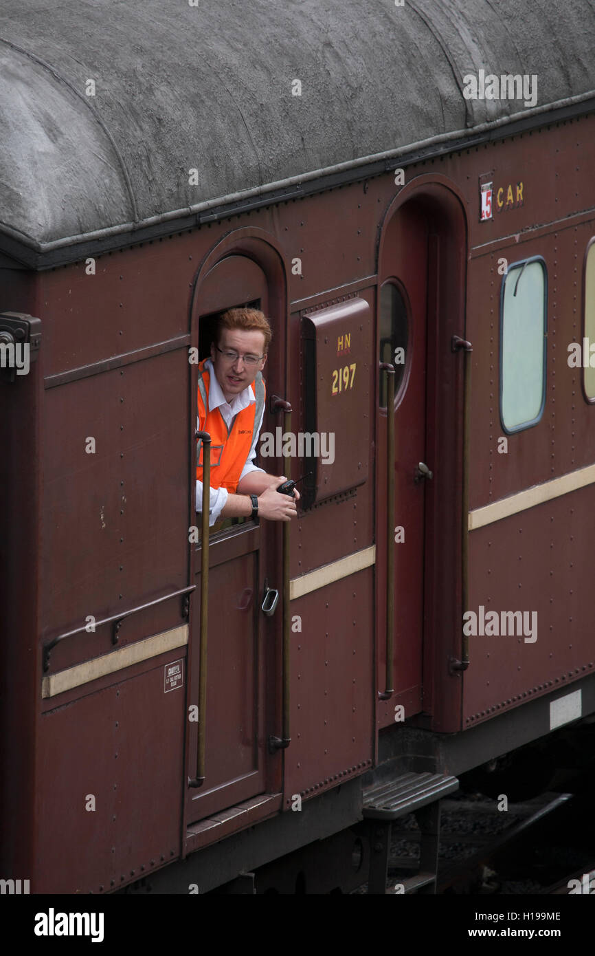 Train guard looking out of the heritage listed passenger train at ...