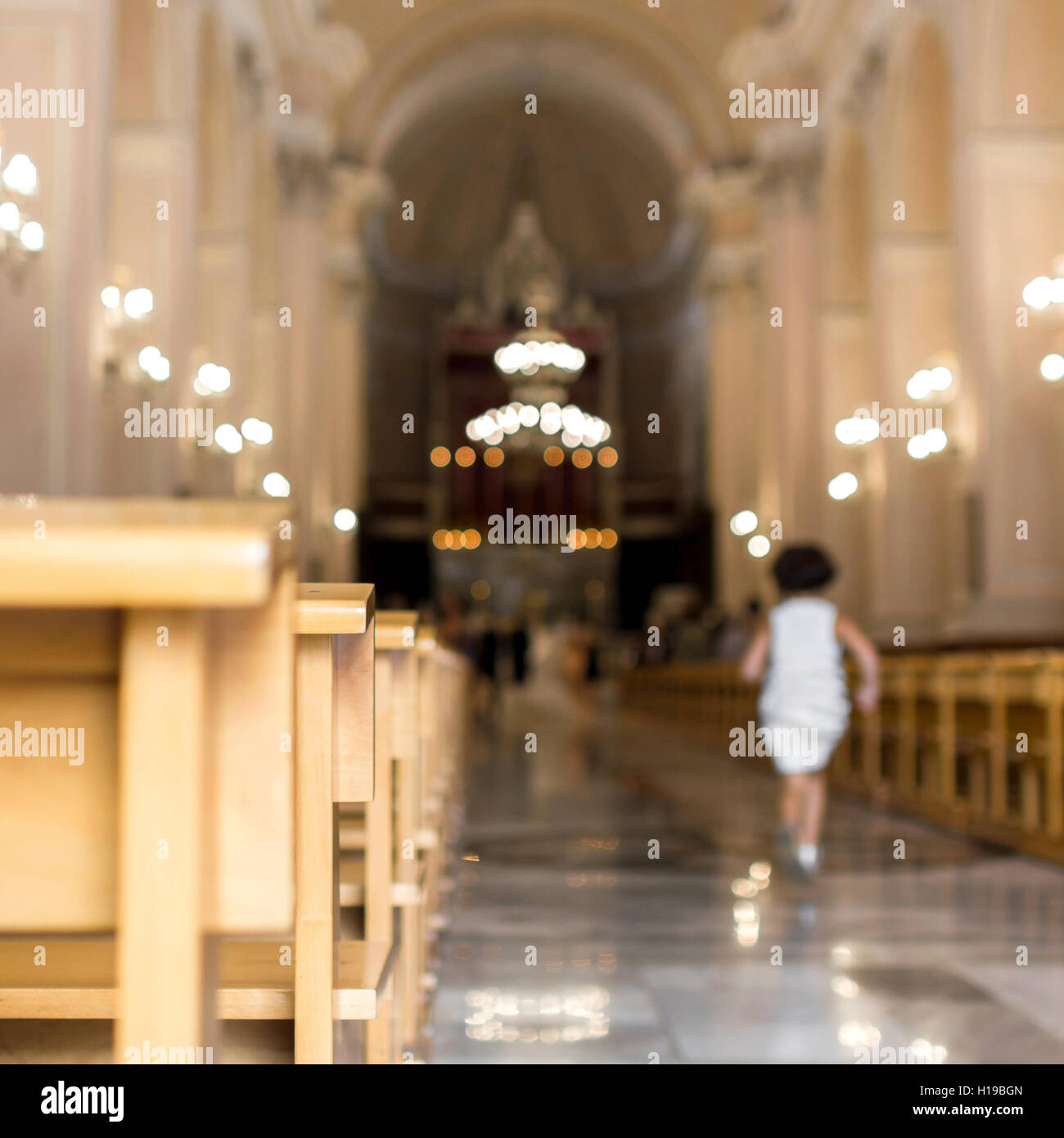 A little girl runs to church, heading for the altar. Defocused blurry ...