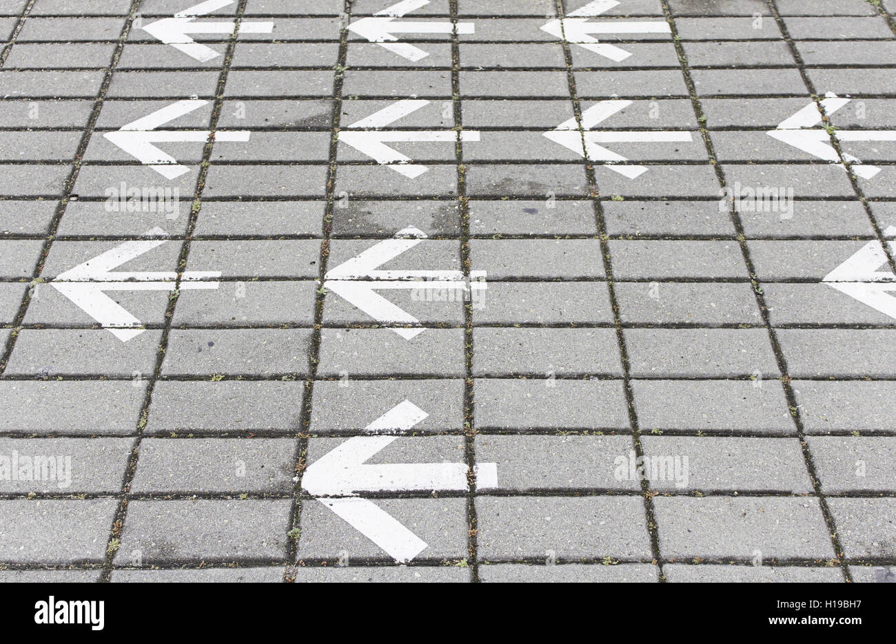 Arrows in tile street, symbol and address Stock Photo - Alamy