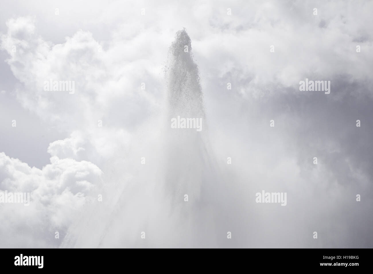 Urban water jet fountain with cloudy sky Stock Photo - Alamy