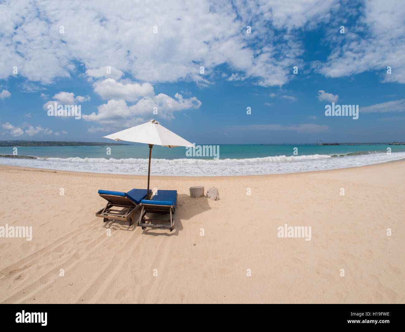 Relaxing couch chairs with parasol on white sandy Beach looking towards ...