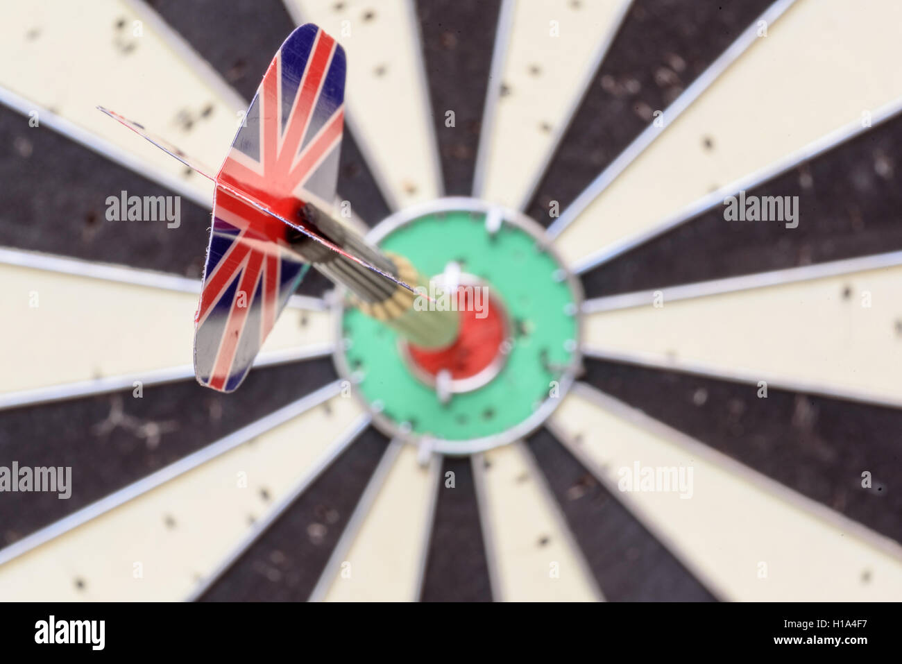 Union Jack flag dart stuck into a red bullseye on a used dart board ...