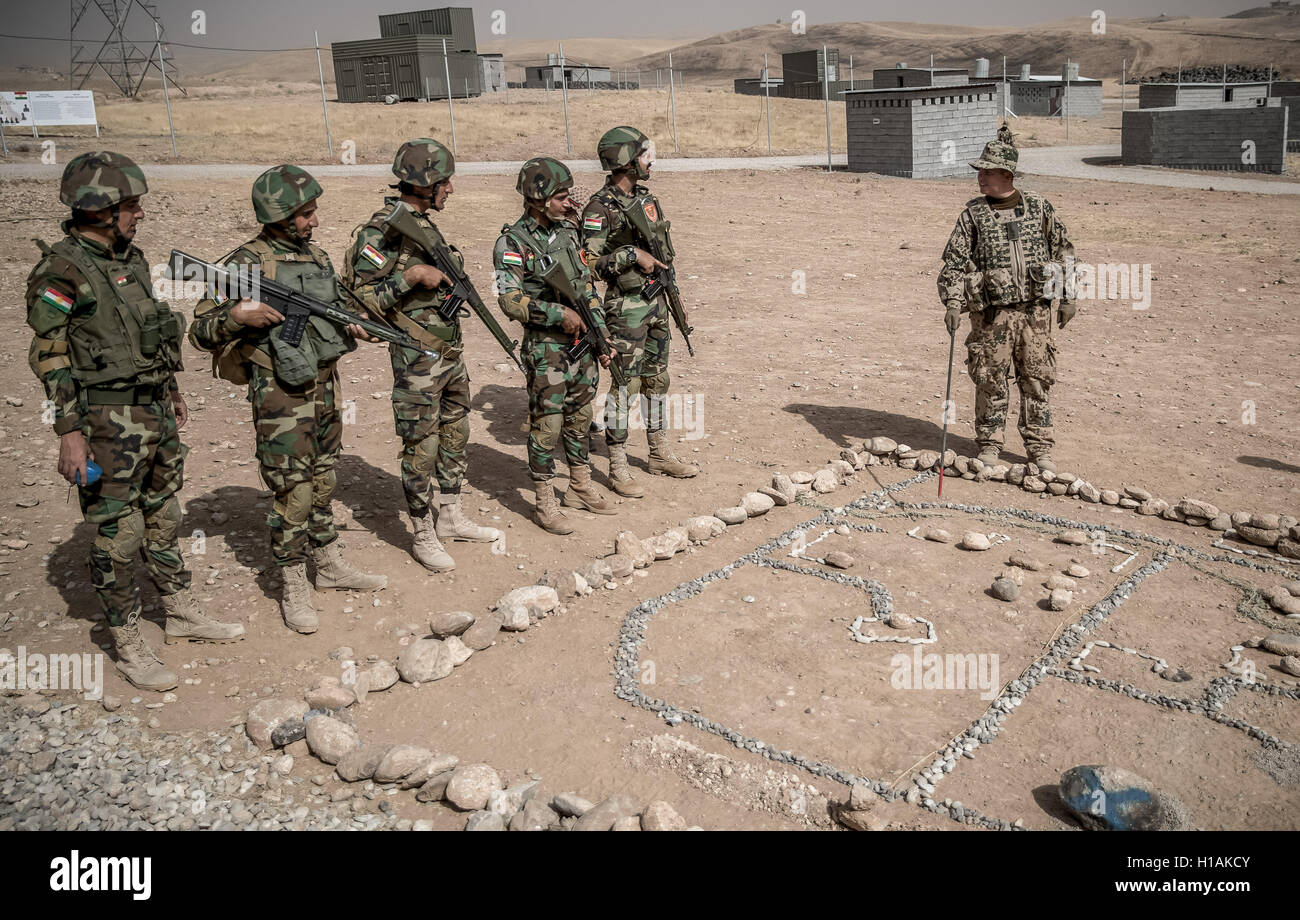 A soldier of the German Bundeswehr (r) teaching soliders of the Kurdish ...