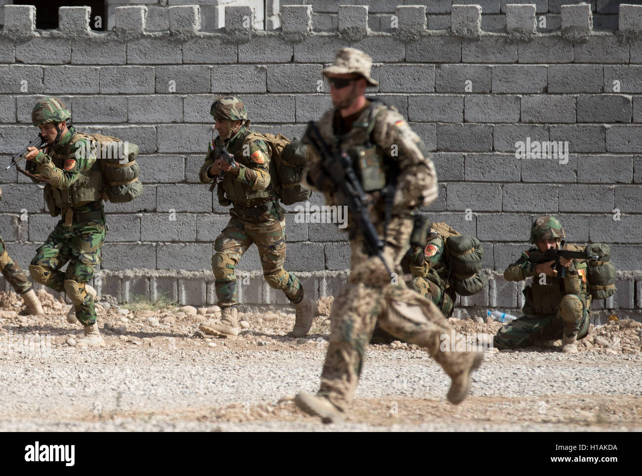 A German Bundeswehr soldier and Kurdish Peshmerga soldiers practicing a ...
