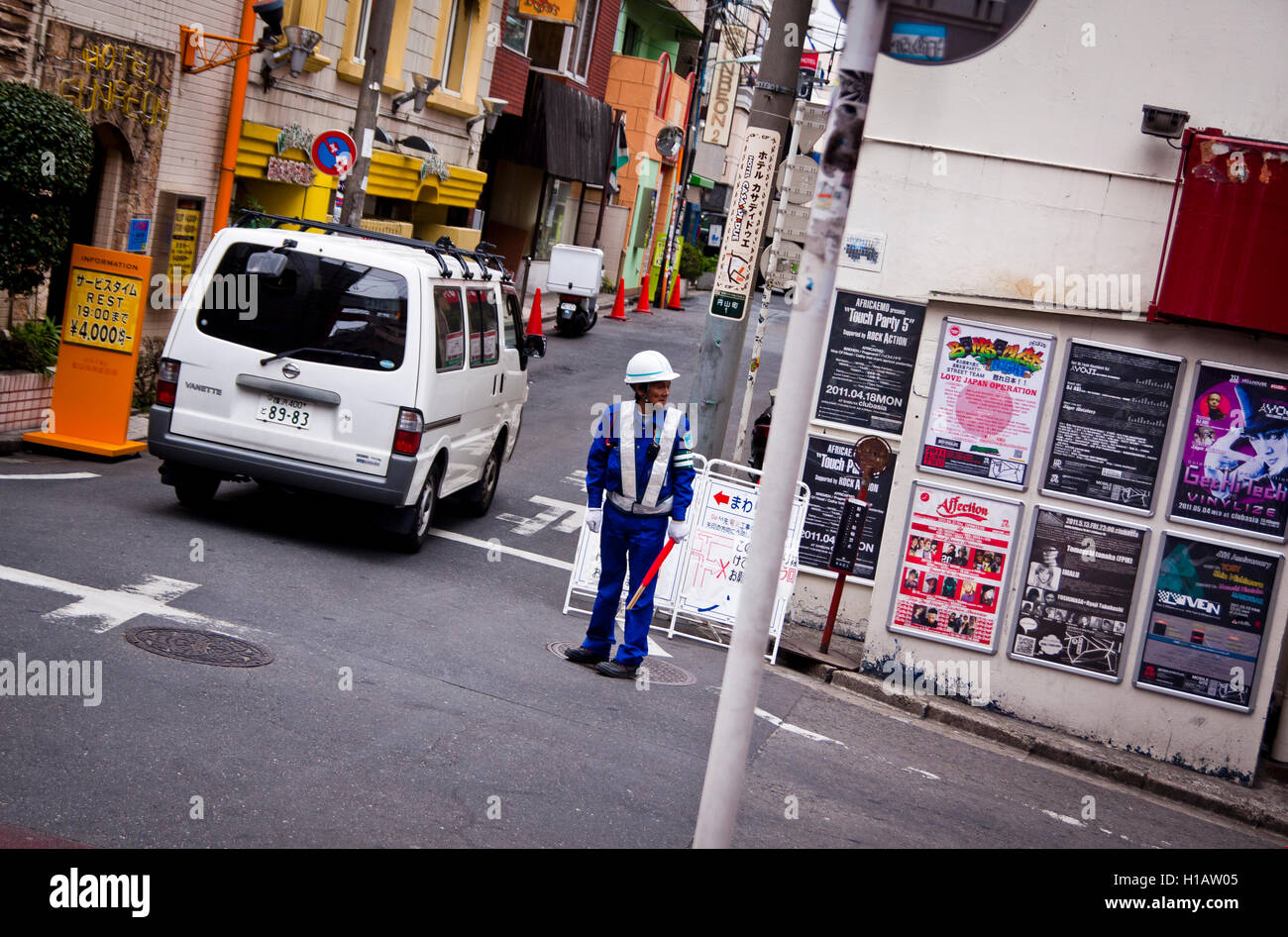 A construction worker directs traffic in Tokyo, Japan Stock Photo - Alamy