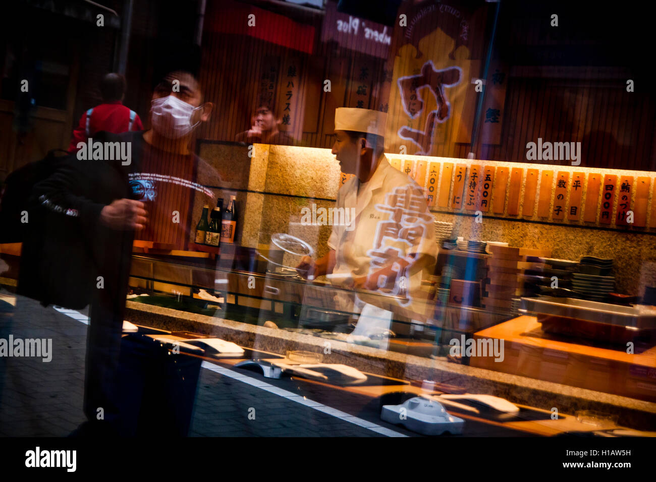 Pedestrians walk past a sushi bar in Tokyo, Japan Stock Photo - Alamy