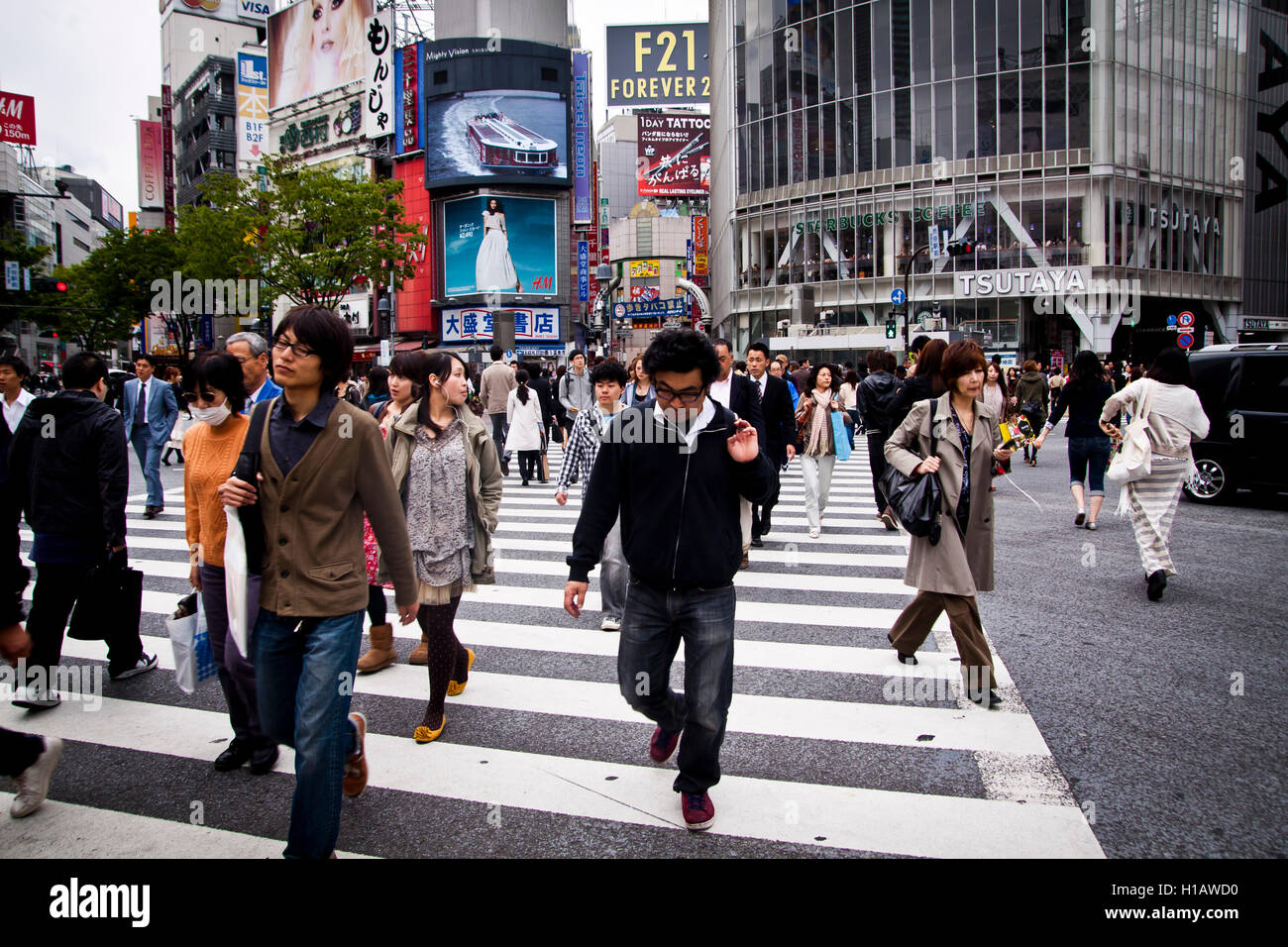 People cross a zebra crossing in the Shinjuku area of Tokyo, Japan ...