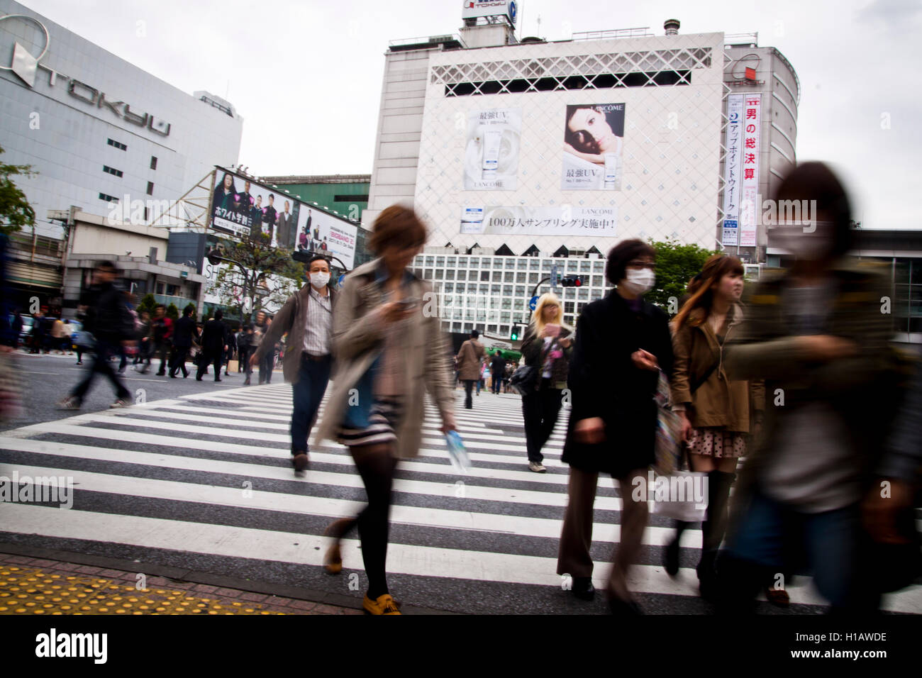 People cross a zebra crossing in the Shinjuku area of Tokyo, Japan ...