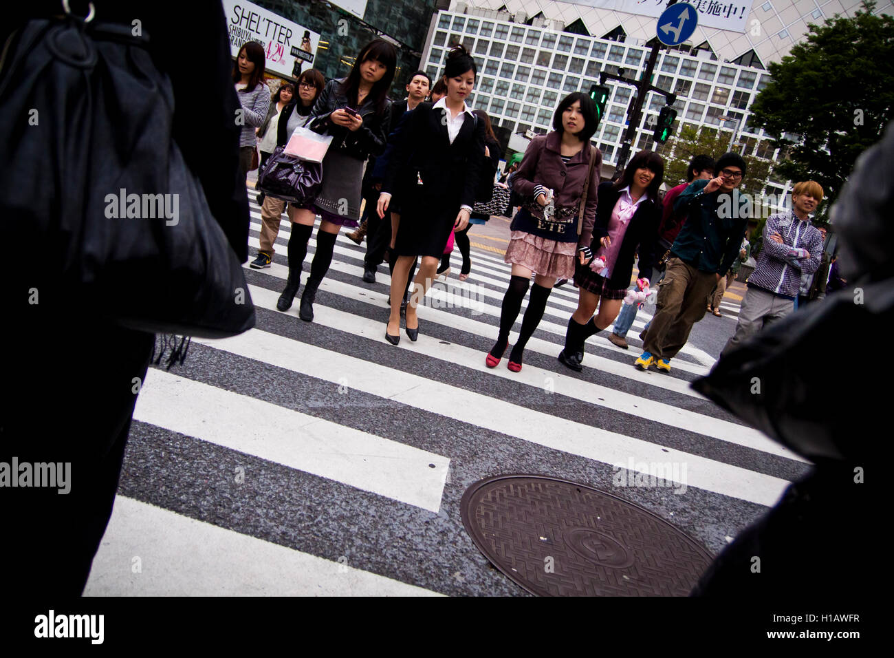 People cross a zebra crossing in the Shinjuku area of Tokyo, Japan ...