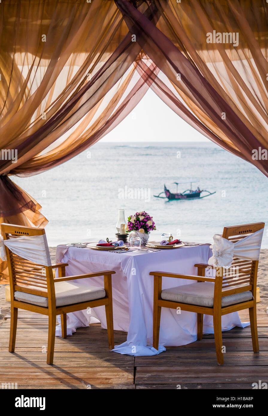 Romantic dinner table set on the beach Stock Photo - Alamy