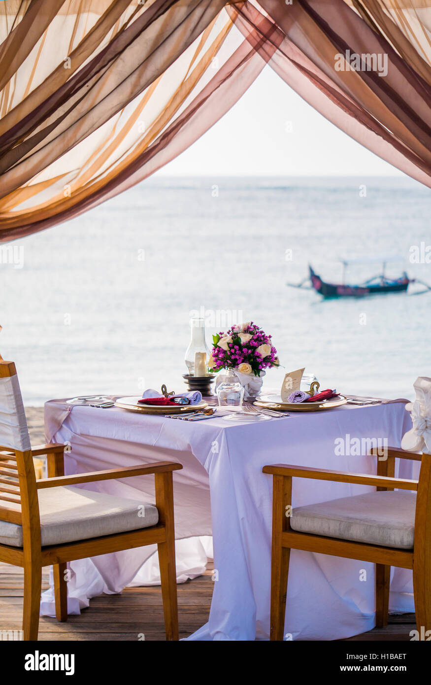 Romantic dinner table set on the beach Stock Photo - Alamy