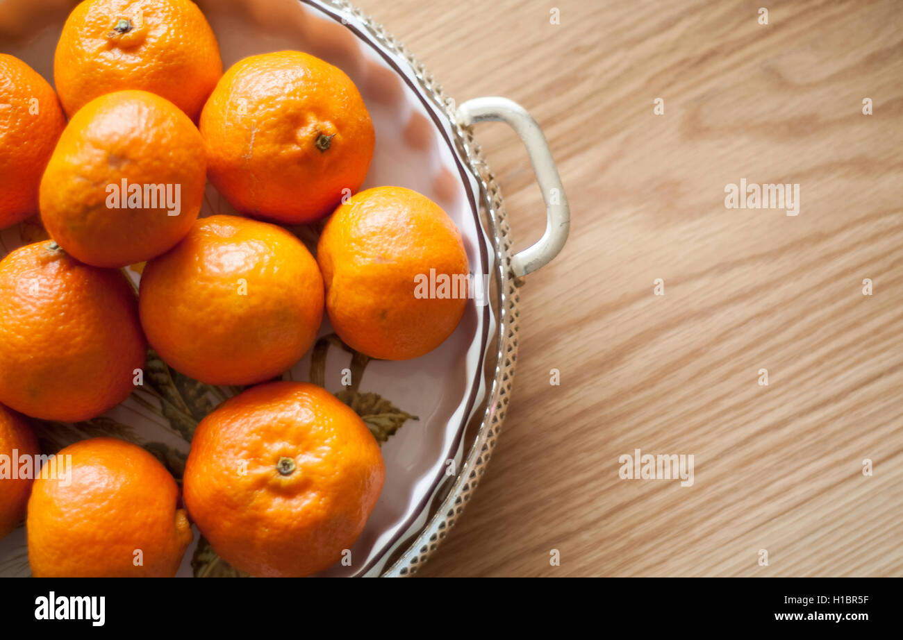 bright orange citruce fruit in a traditional dish on a wooden table ...