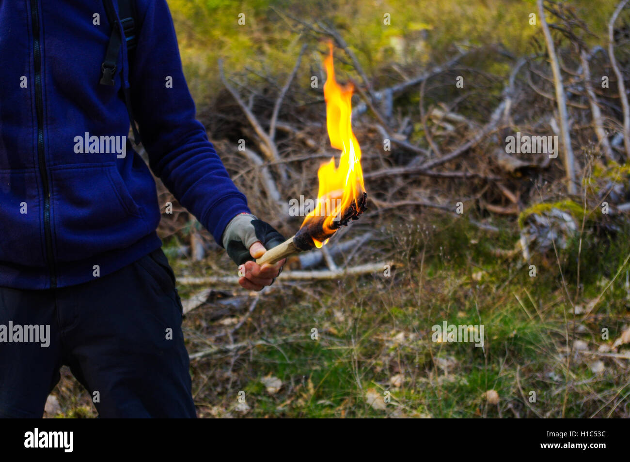 part of a man and hand with torch flame in wild nature background Stock ...