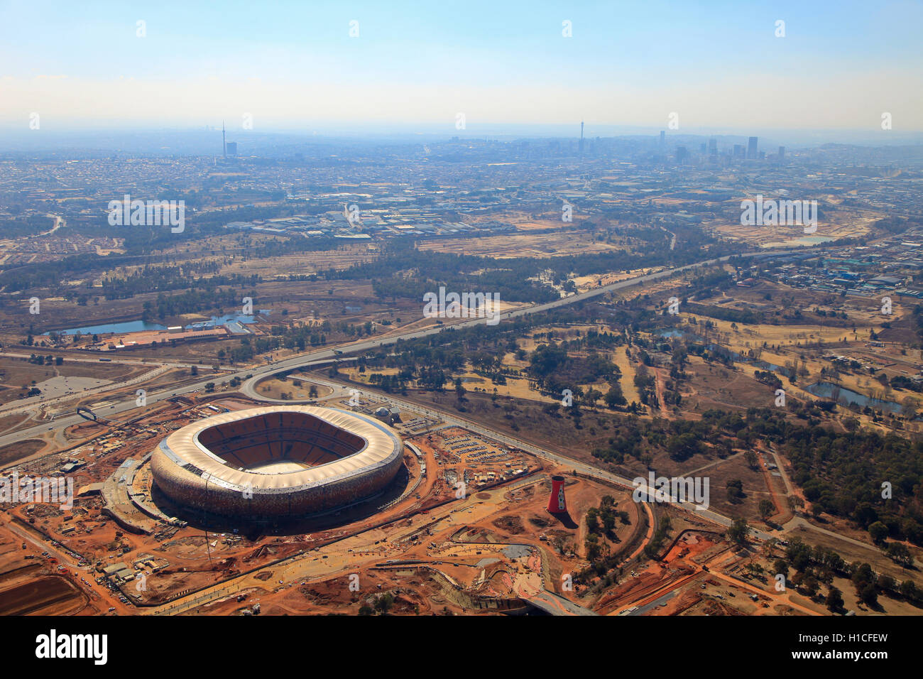 Aerial photograph of the Soccer-City, FNB-Stadium with the skyline of ...