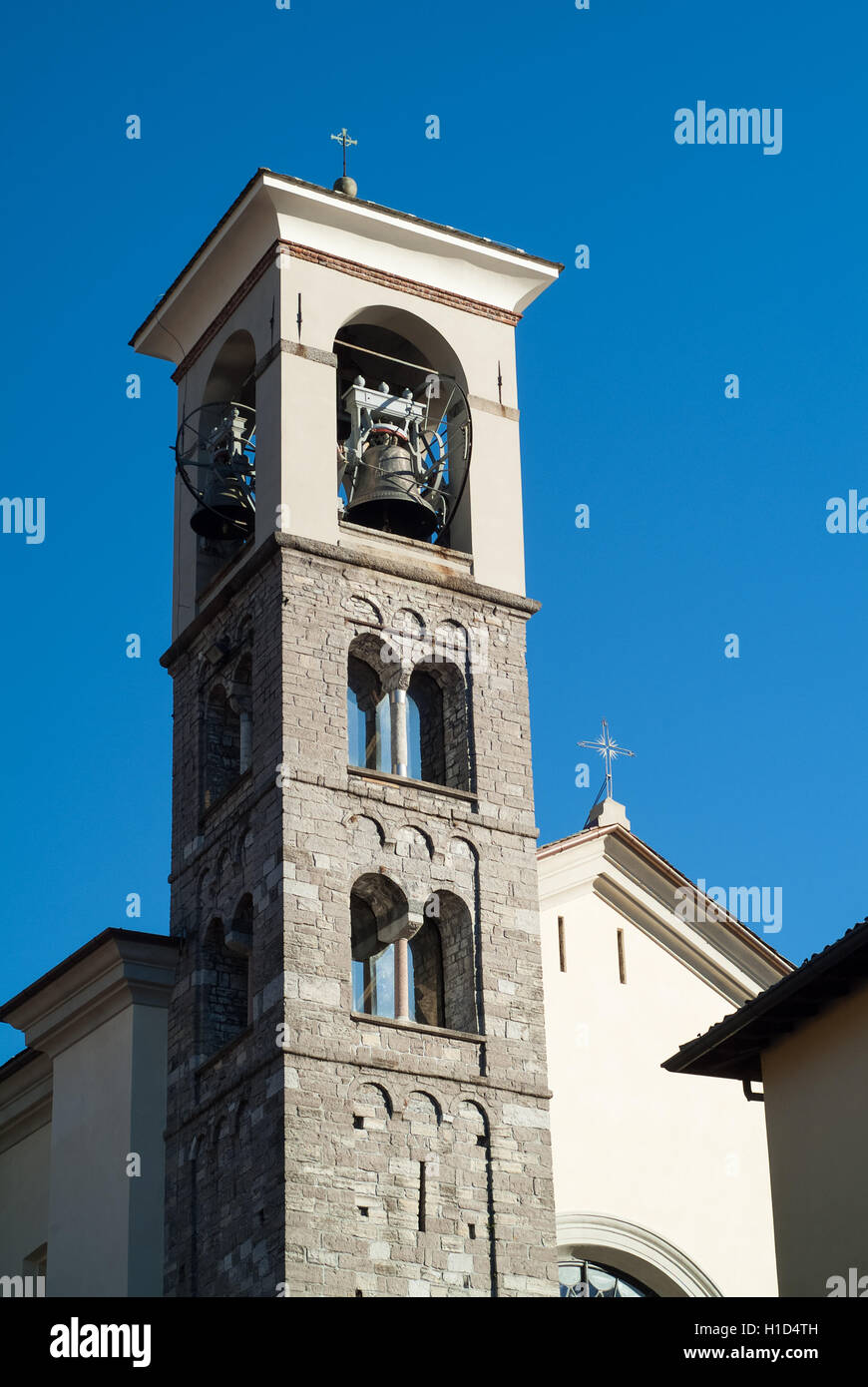 a stone bell tower photographed against blue sky in Mandello del Lario ...
