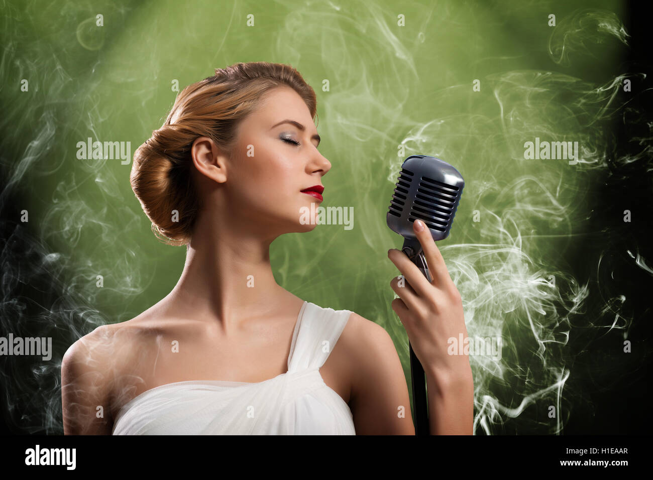 beautiful blonde woman singer with a microphone Stock Photo - Alamy