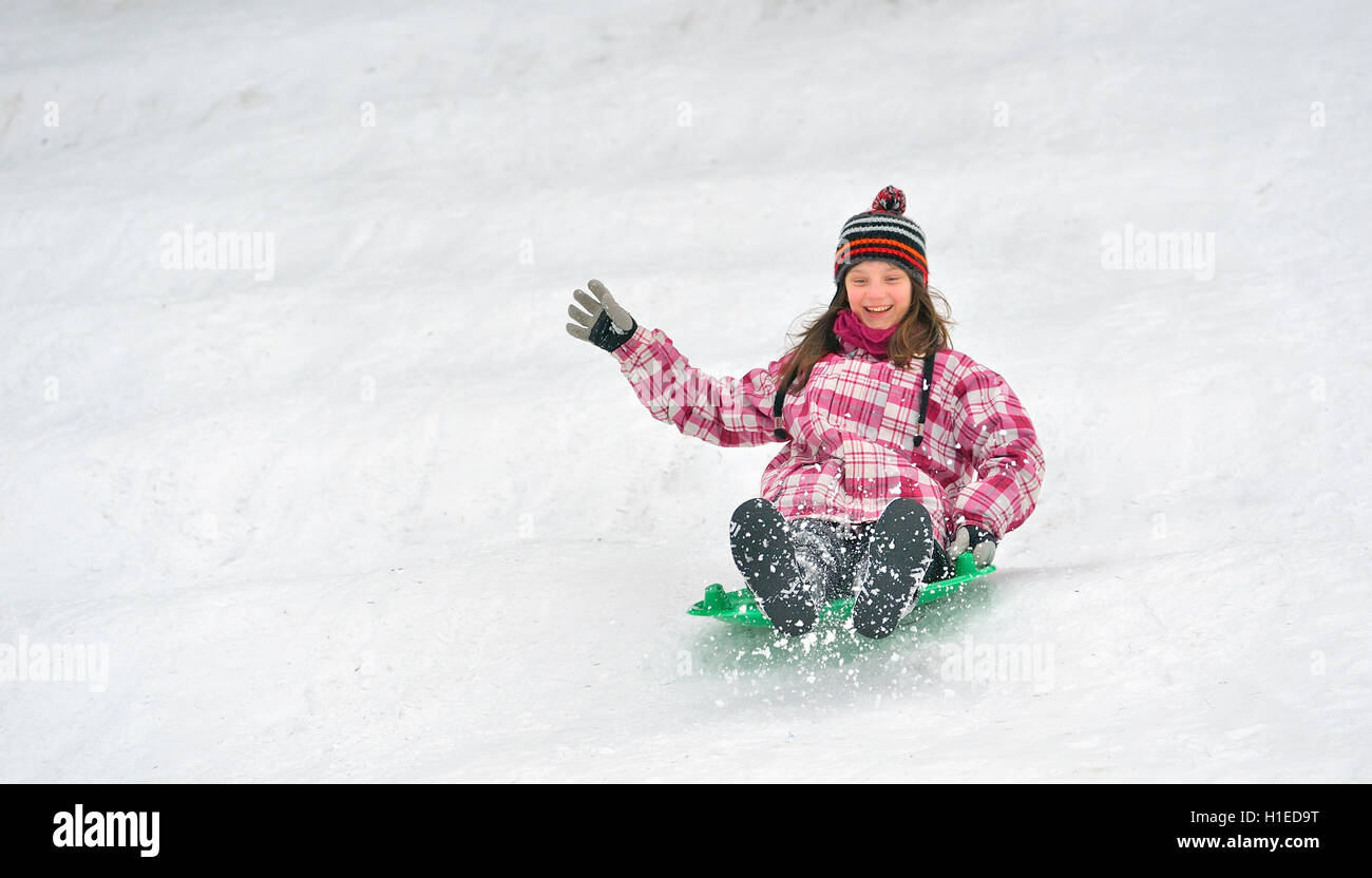 girl sliding on sled Stock Photo - Alamy