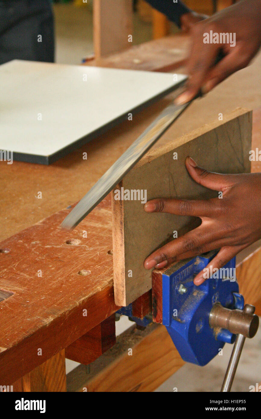School boy filing wood in woodwork classroom, St Mark's School, Mbabane ...