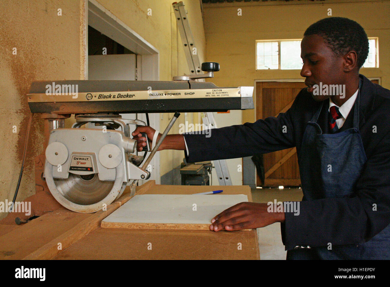 School boy using cut saw in woodwork classroom, St Mark's School ...