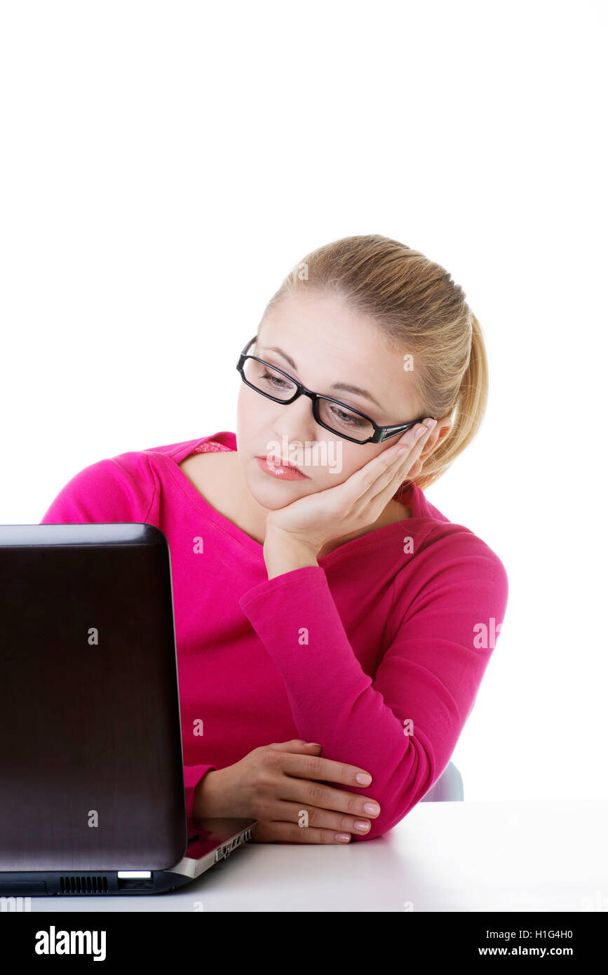 Bored, sad woman sitting in front of laptop Stock Photo - Alamy