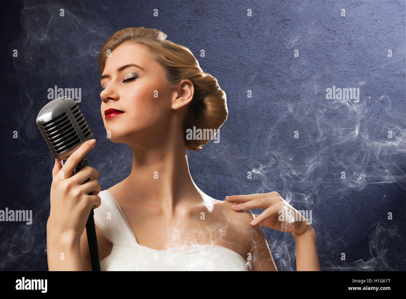 beautiful blonde woman singer with a microphone Stock Photo - Alamy