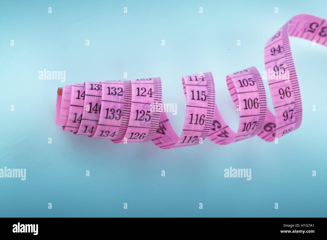 Coiled pink textile tape measure Stock Photo - Alamy