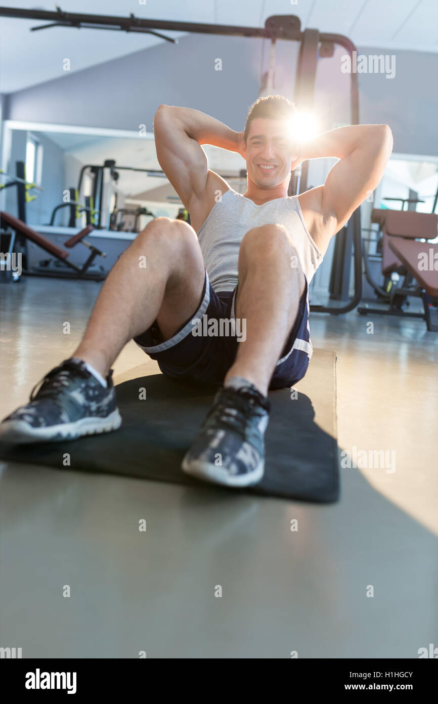 Male fitness model doing sit ups and crunches exercising abdominal ...