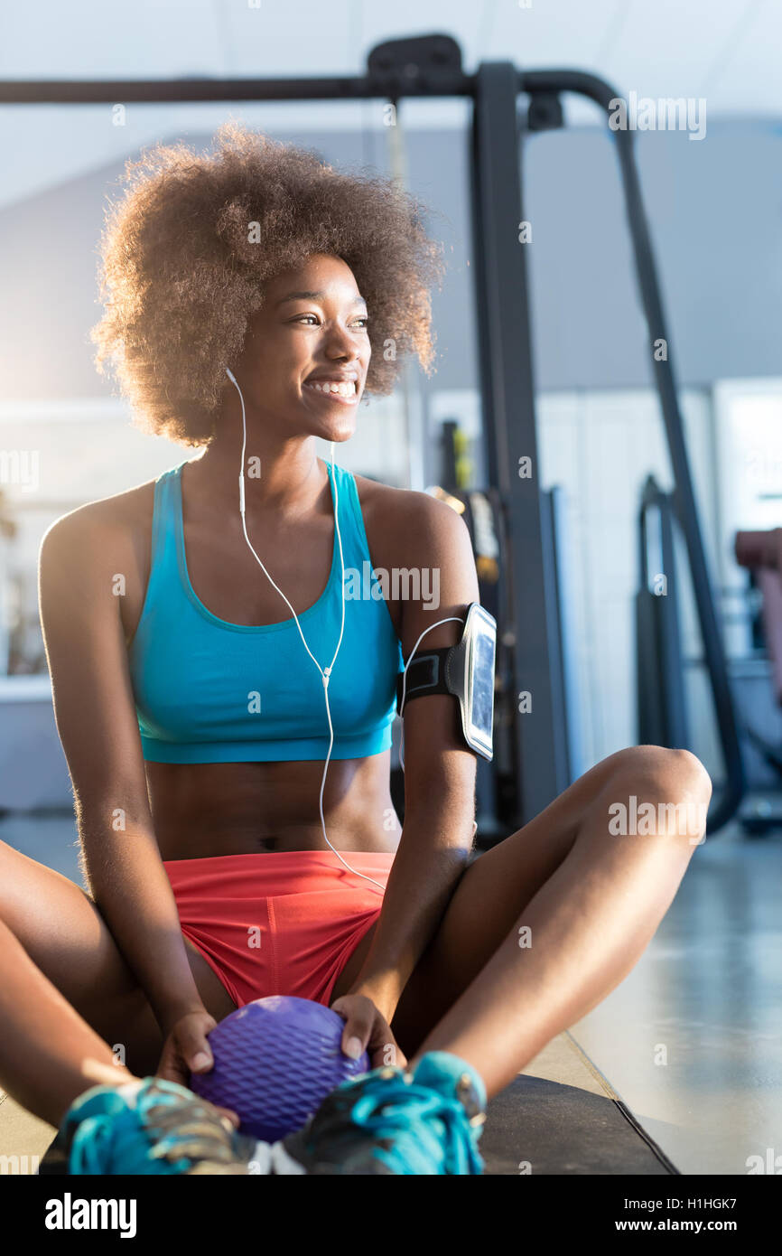 Portrait of pretty fit girl in sport clothes with balance ball in gym ...