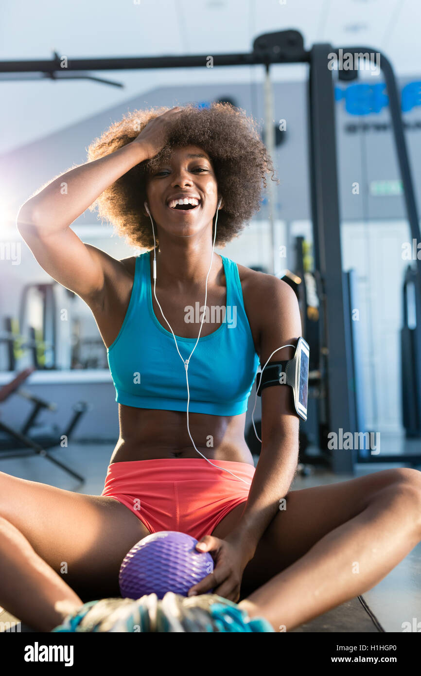 Happy healthy young African American woman working out and listening to ...