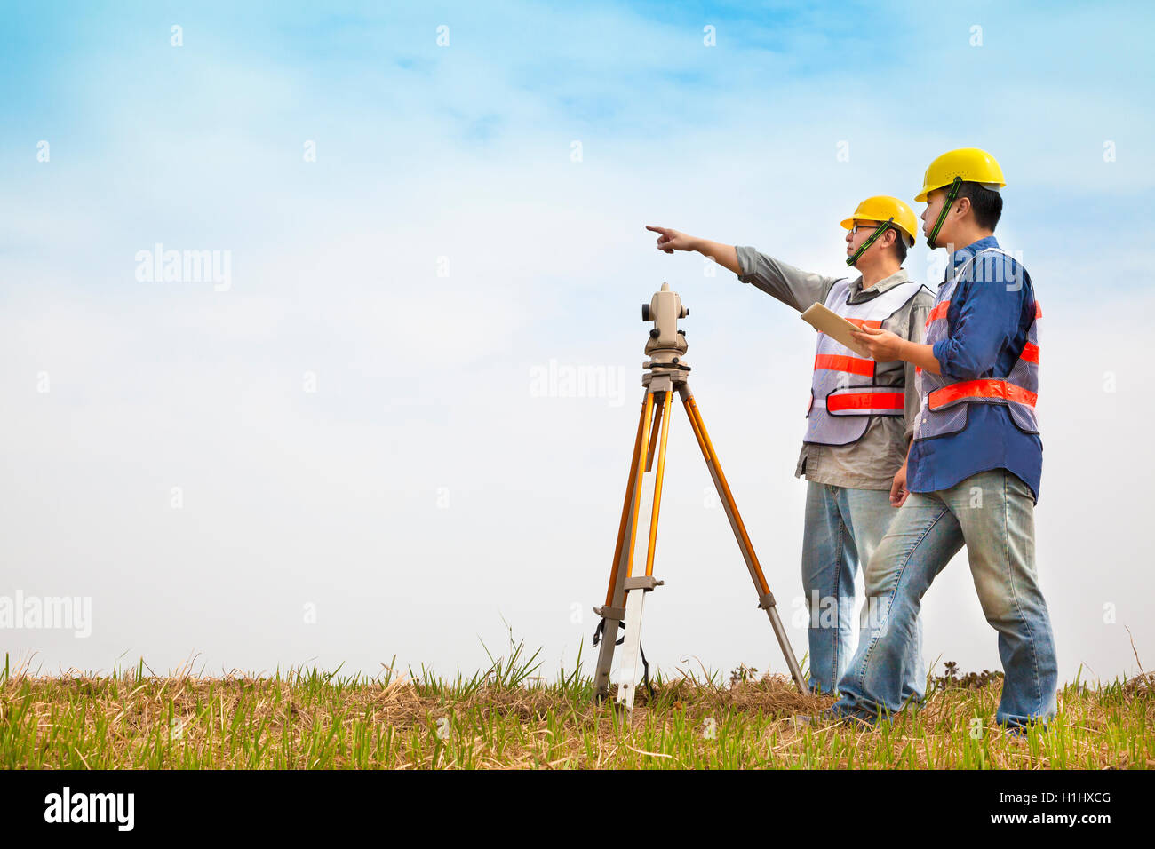 Surveyor engineer making measure with partner on the field Stock Photo ...
