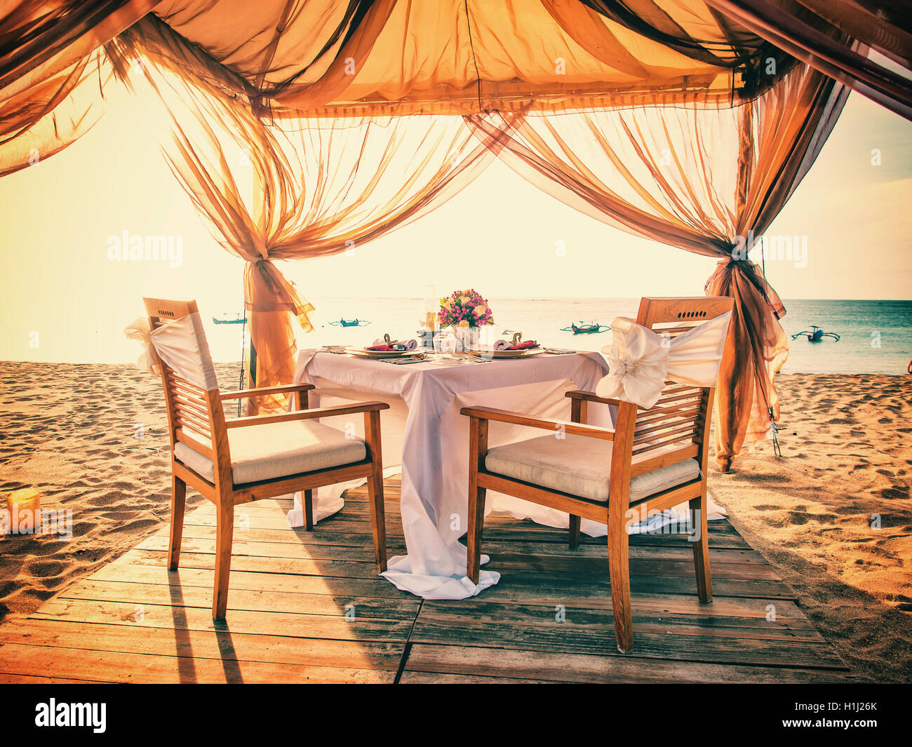 Romantic dinner setting on the beach at sunset Stock Photo - Alamy