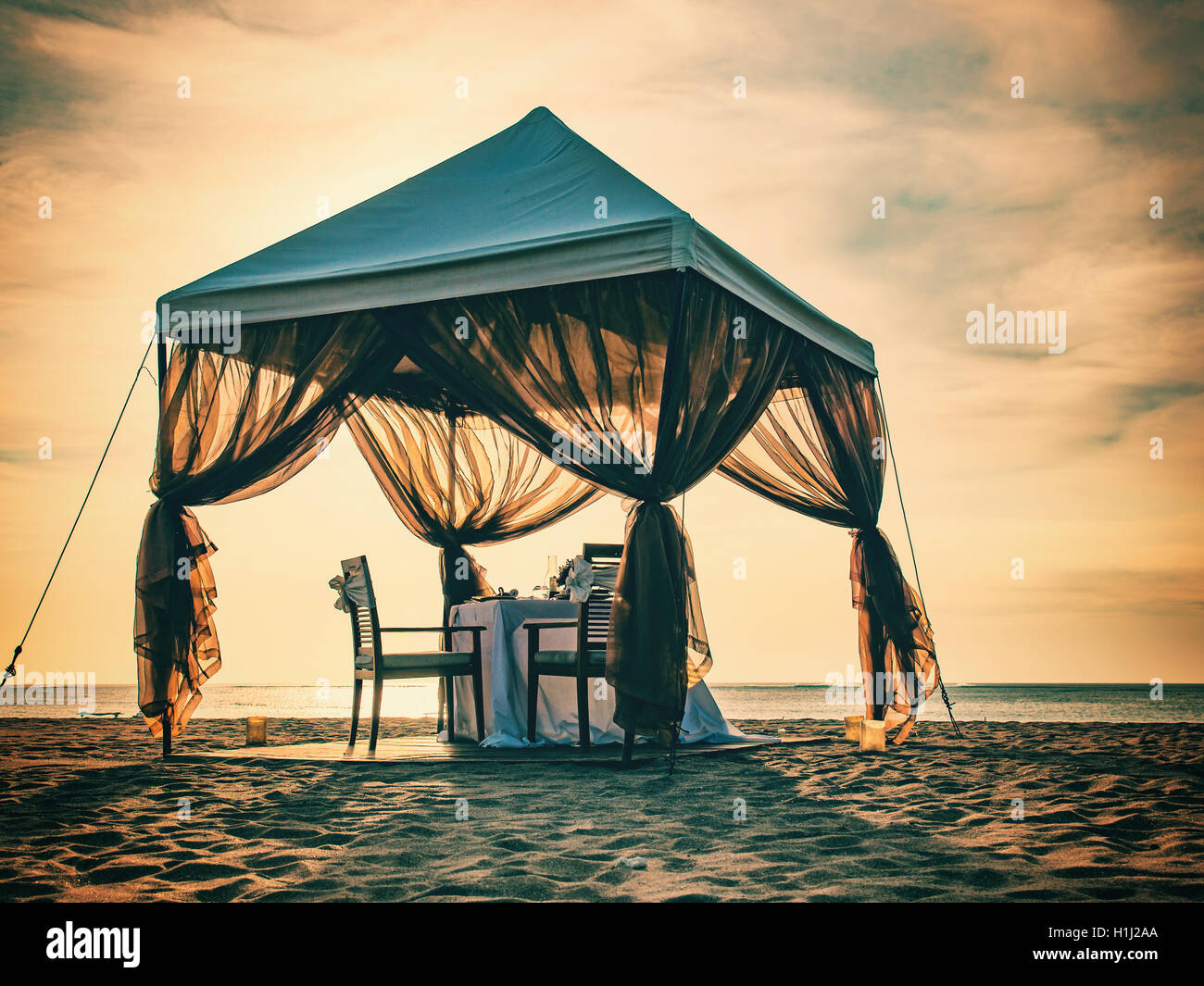 Romantic dinner setting on the beach at sunset Stock Photo - Alamy