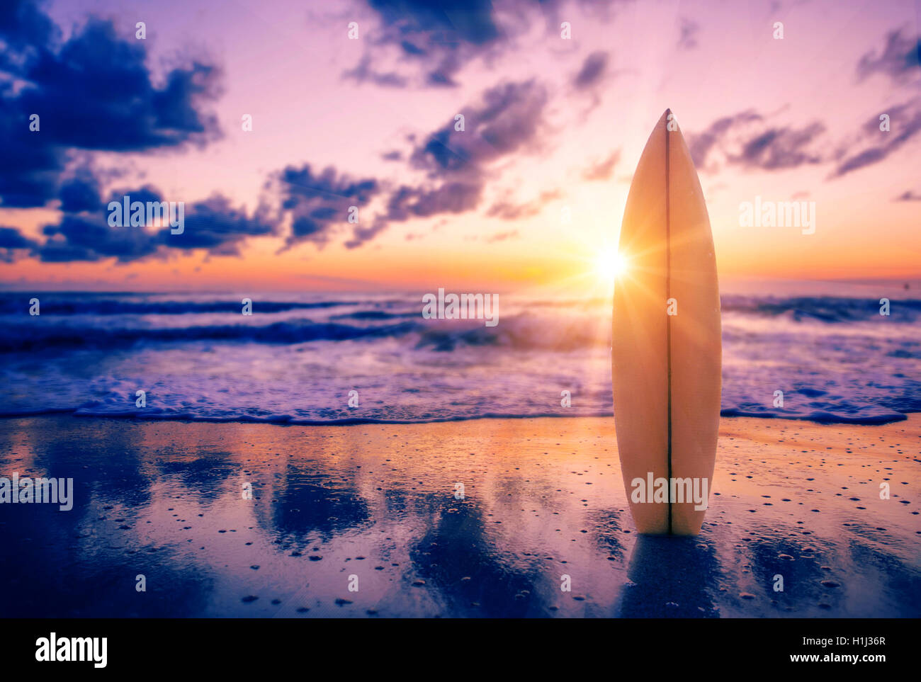 Surfboard on the beach at sunset Stock Photo - Alamy
