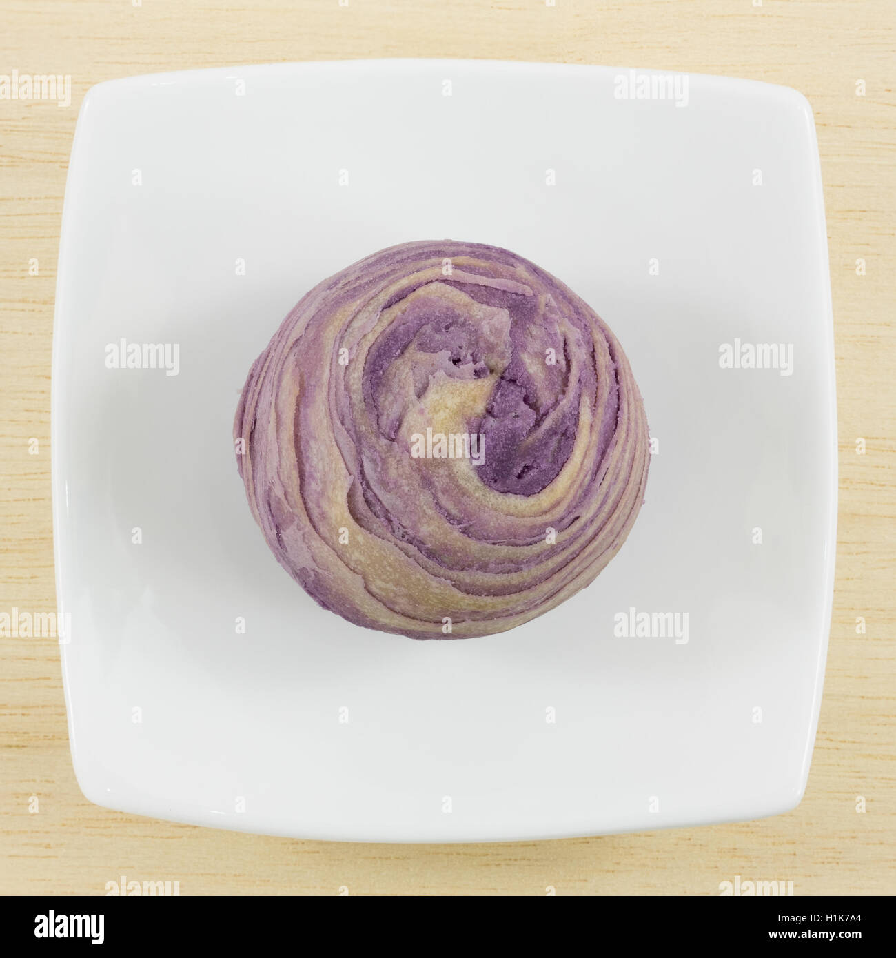 The Taiwanese violet crystal taro cake on the small white square dish ...