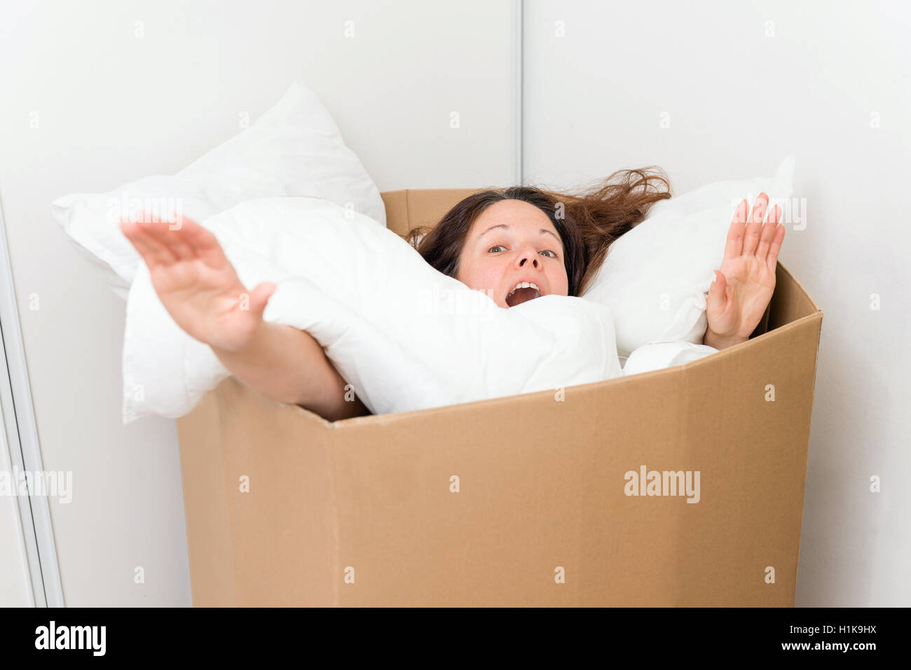 Young woman drowning in a box Stock Photo - Alamy