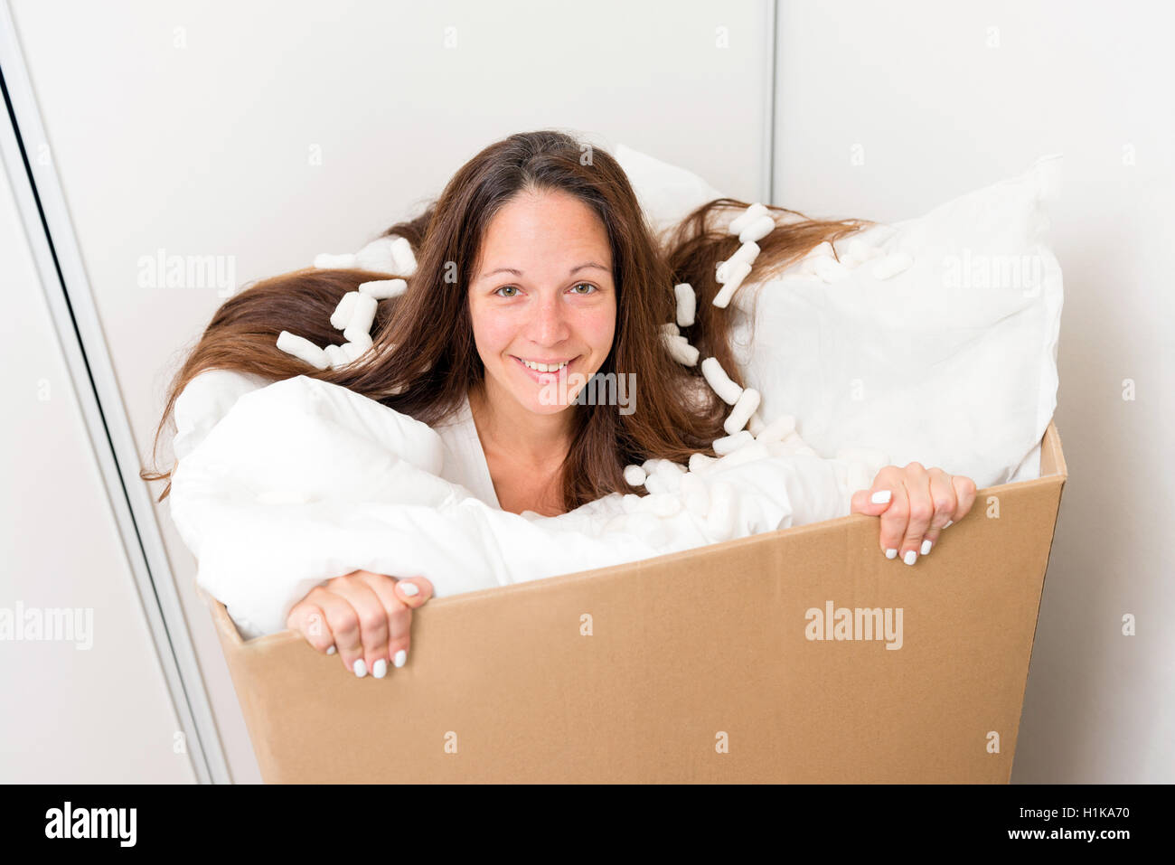 Young woman in a box with packing material Stock Photo - Alamy