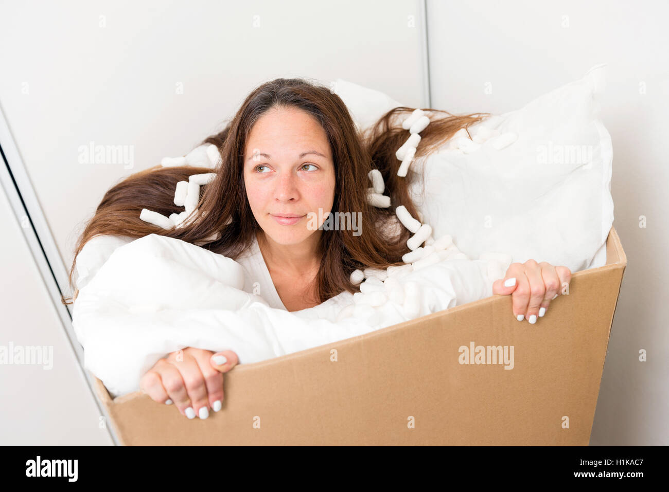 Young woman in a box with packing material Stock Photo - Alamy