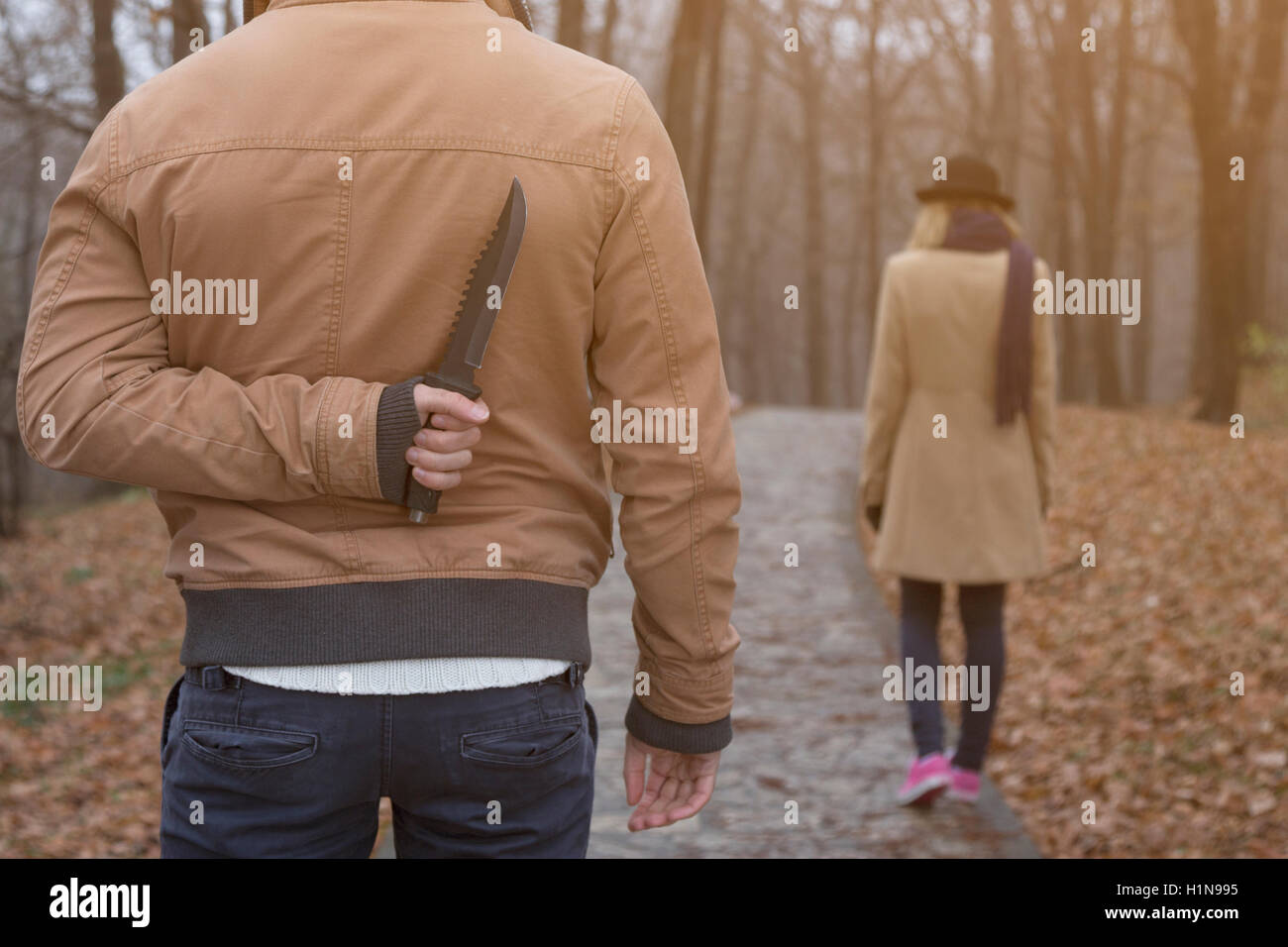 Maniac holding a knife behind his back and waiting for innocent girl to ...