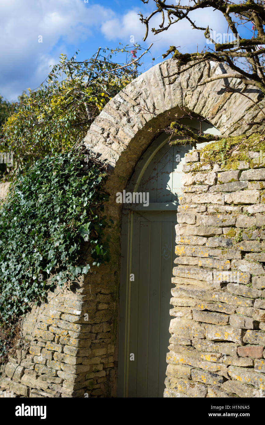 A wooden door hidden in a stone wall Stock Photo - Alamy