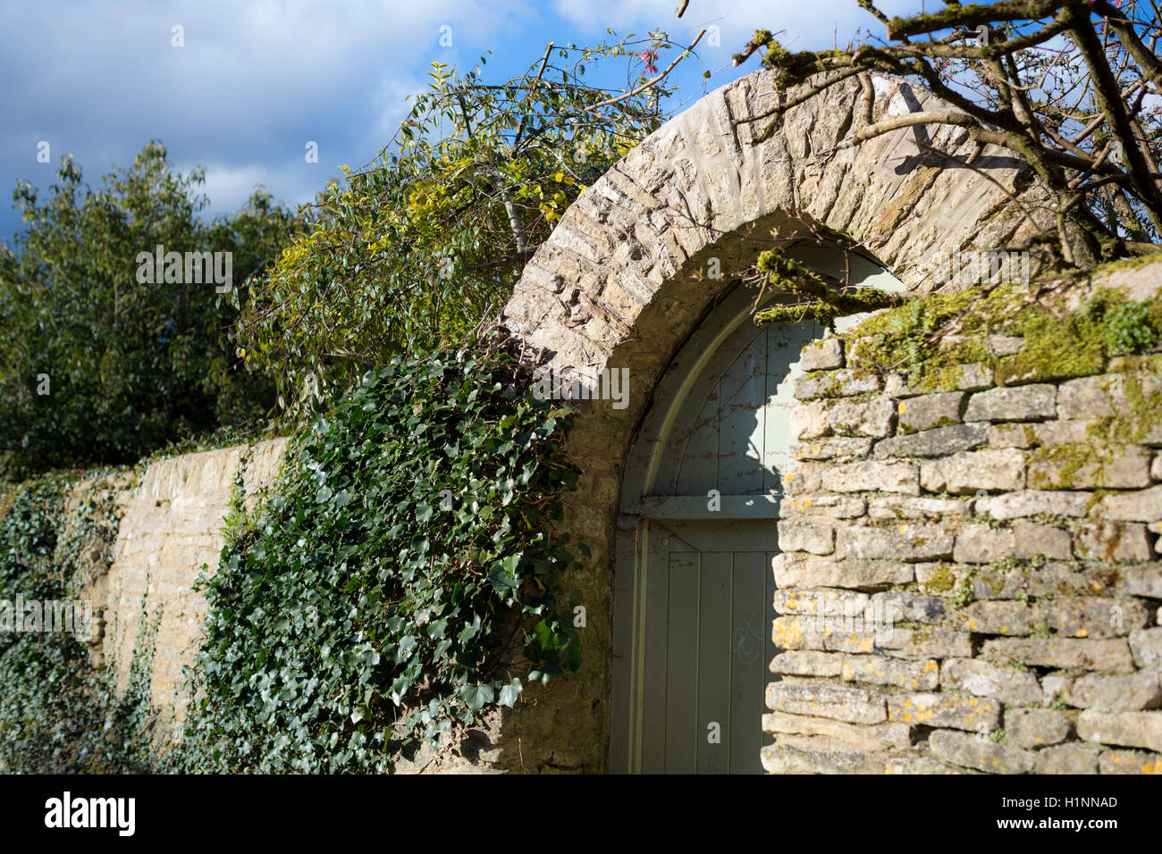 A wooden door hidden in a stone wall Stock Photo - Alamy