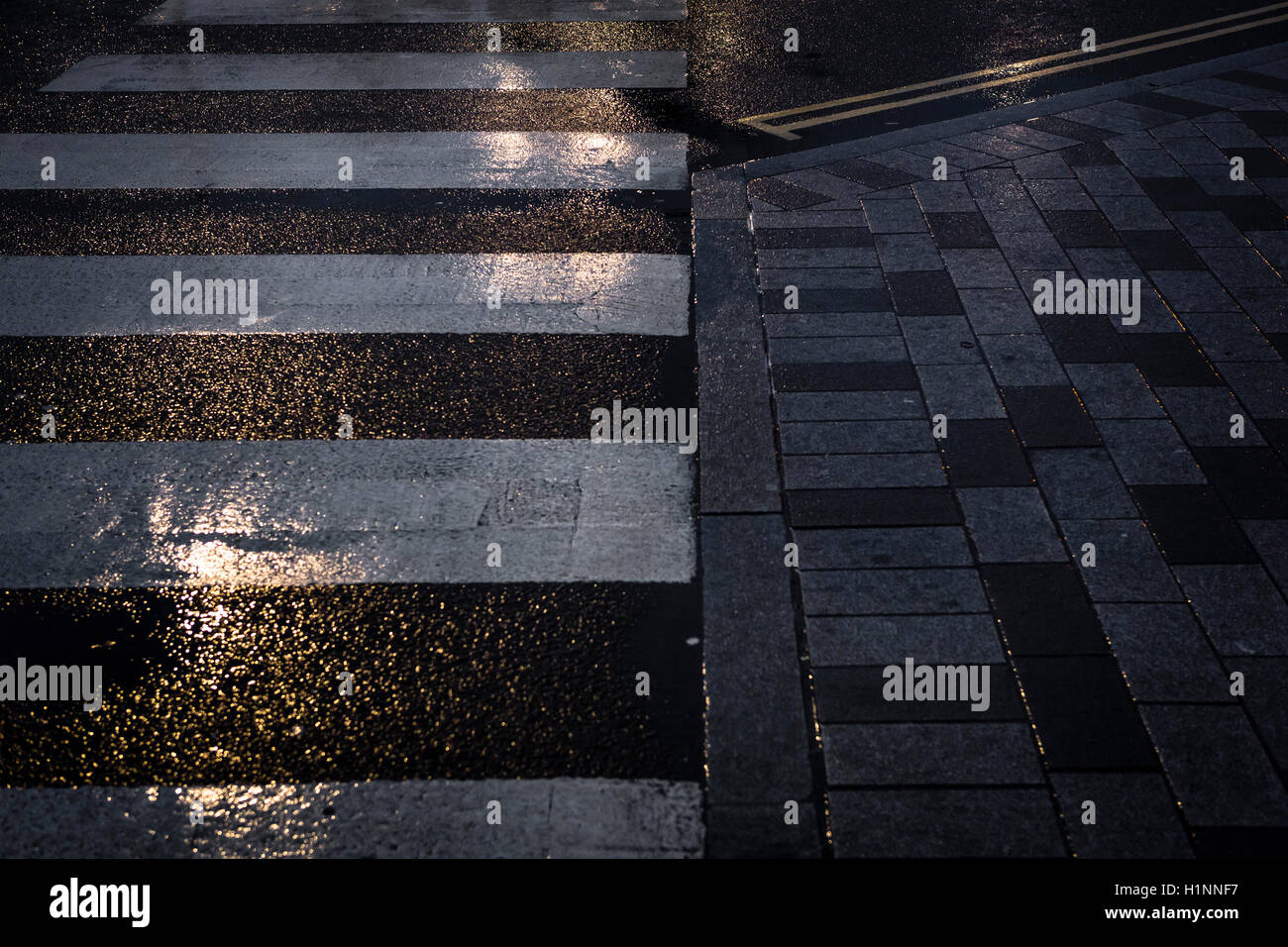 Pedestrian or zebra crossing in the night time with wet rain drenched ...
