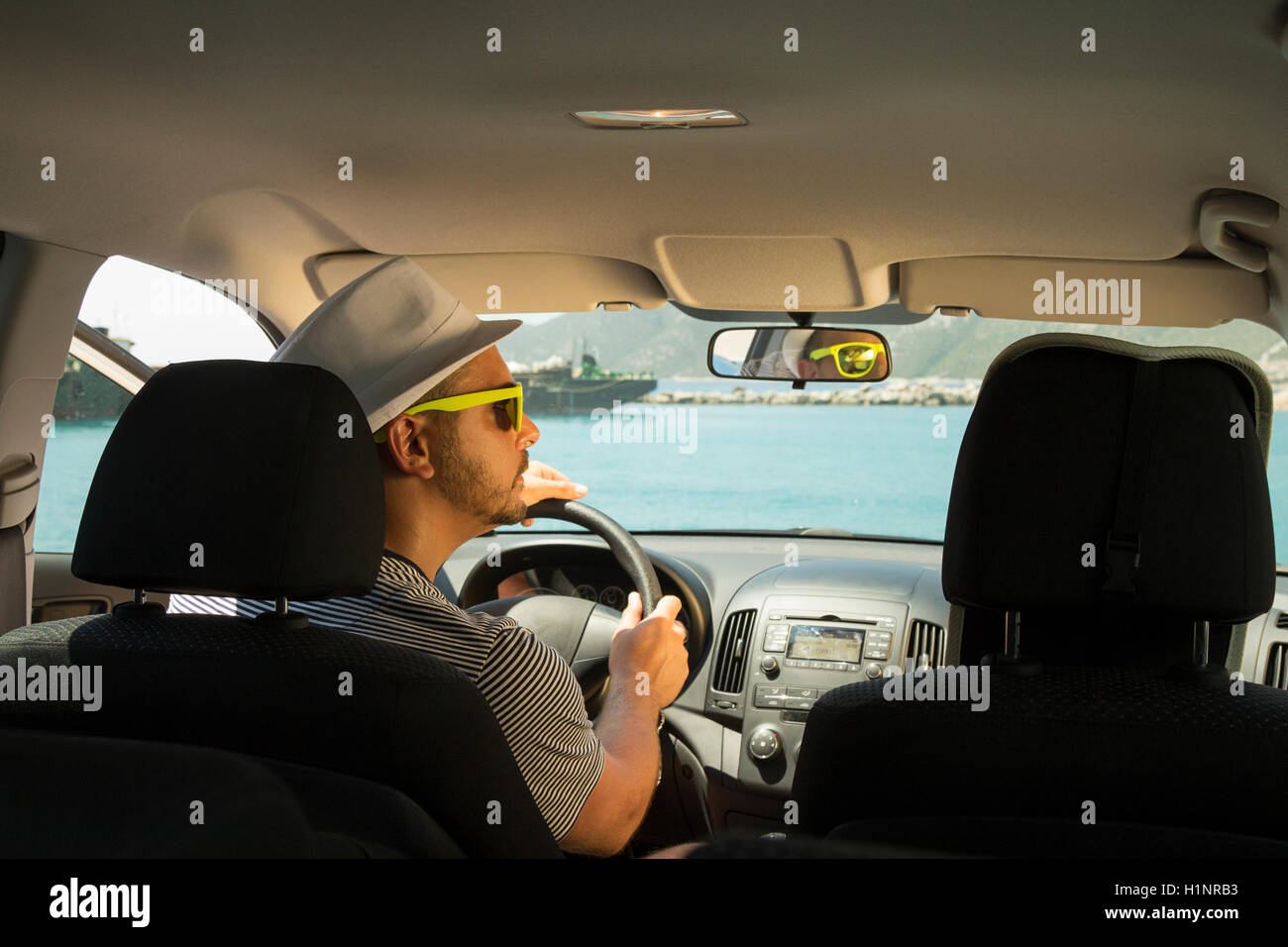 Young man driving a car. Rear point of view Stock Photo - Alamy