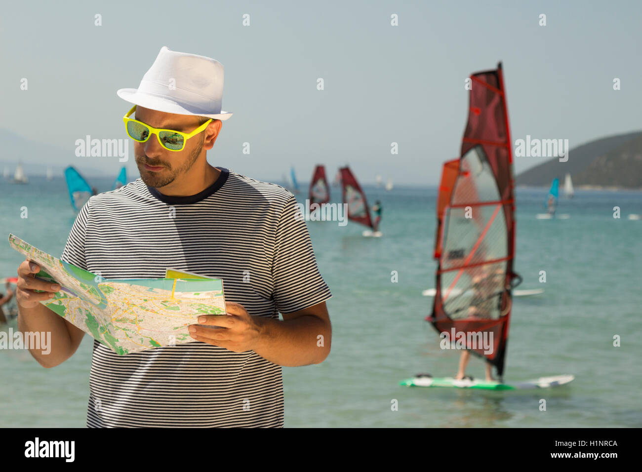 Guy trying to find the right direction by using his map. Windsurfers in ...