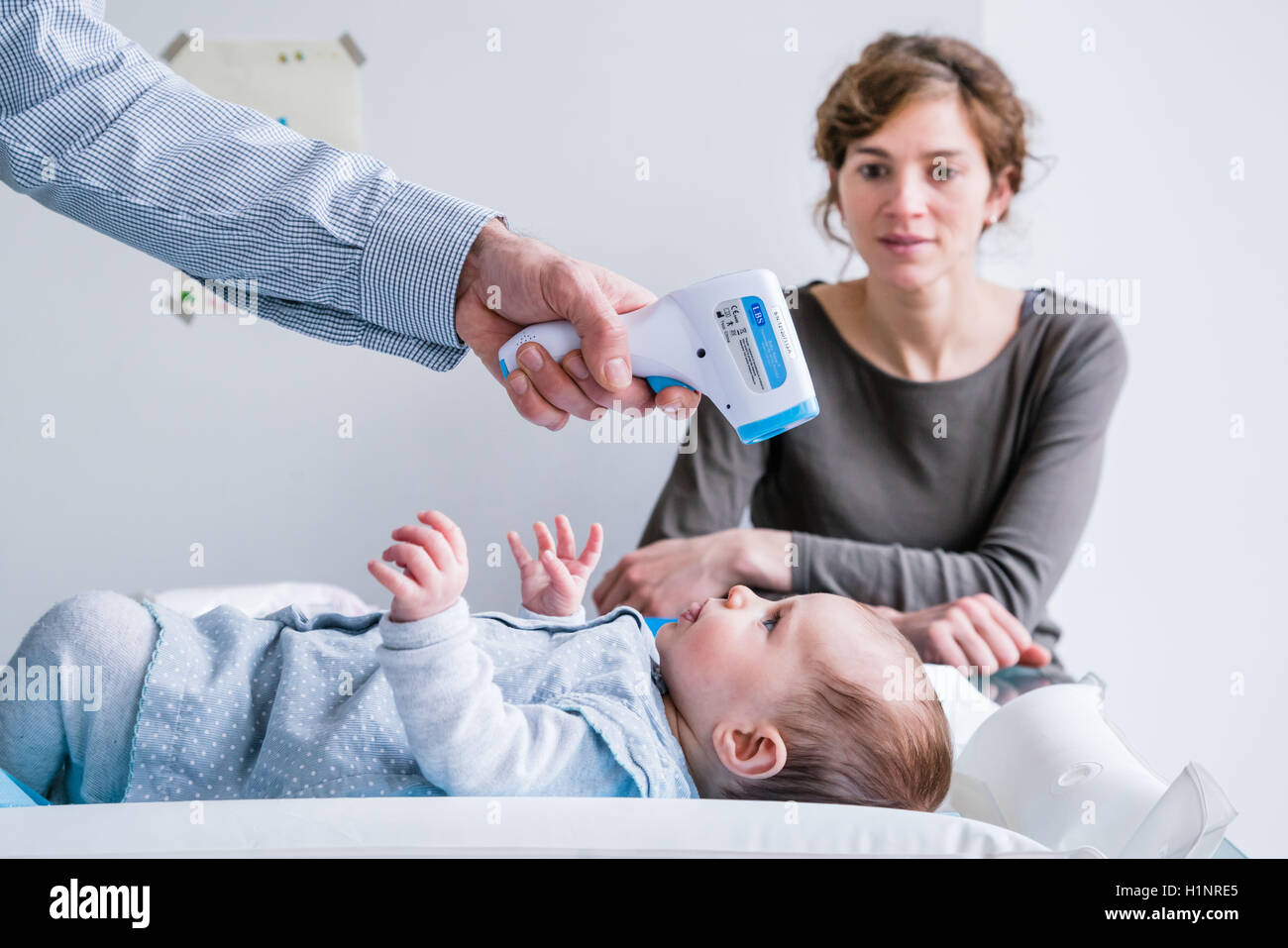 Checking the temperature of a 3 month old baby girl with forehead ...