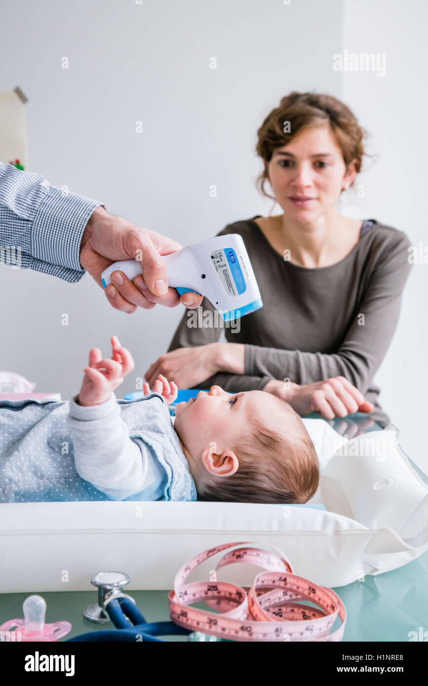 Checking the temperature of a 3 month old baby girl with forehead ...