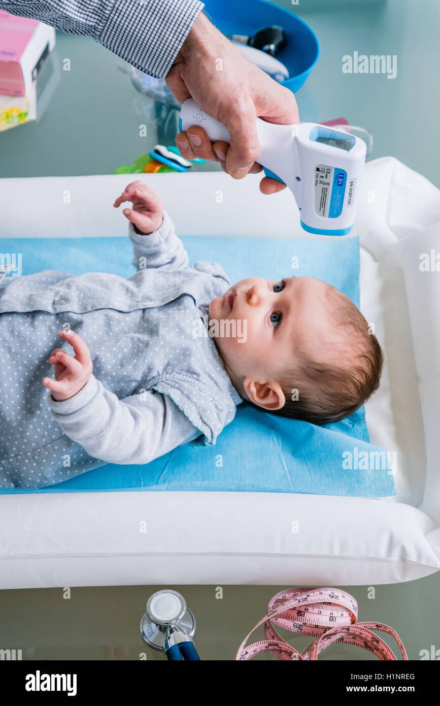 Checking the temperature of a 3 month old baby girl with forehead ...